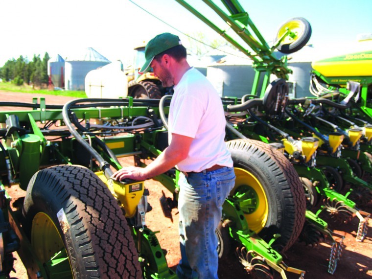 Kadrmas makes adjustments on corn planter, begins planting