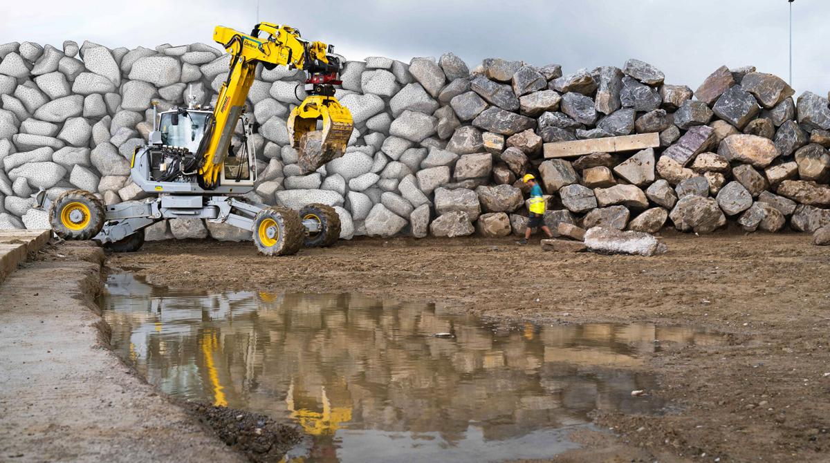 Autonomous excavator builds stone wall