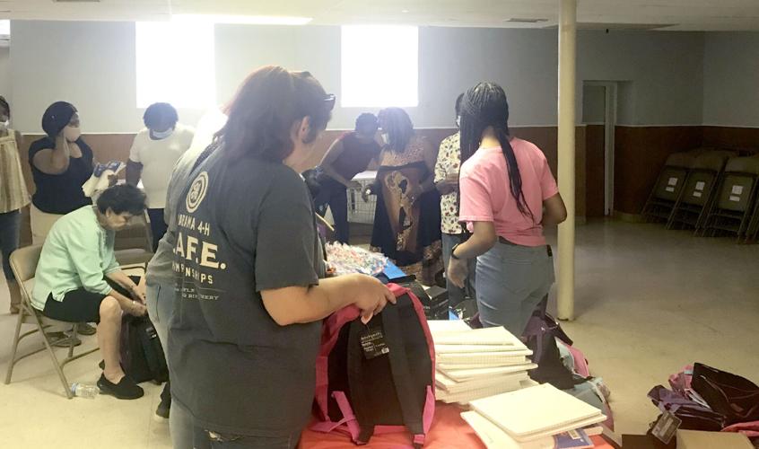 Volunteers load up backpacks to be given to children | News ...