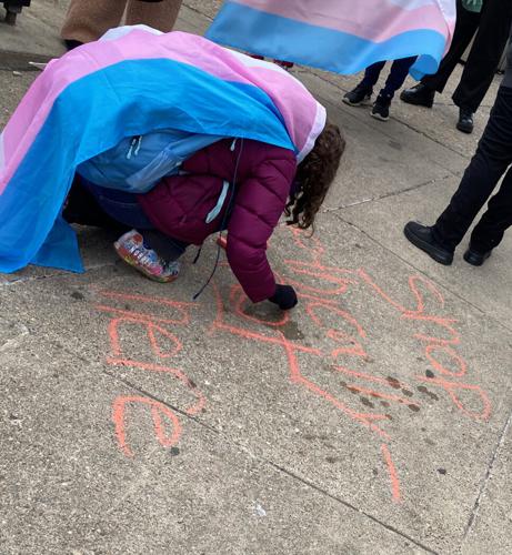 About 100 protest Artifacts for anti-trans signage, business practices ...