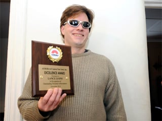 Aurora of CNY gave Lance Lyons an award for excellence. They’re the ...