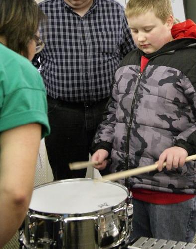 Rebekah Reger teaches Joshua Pohl how to drum