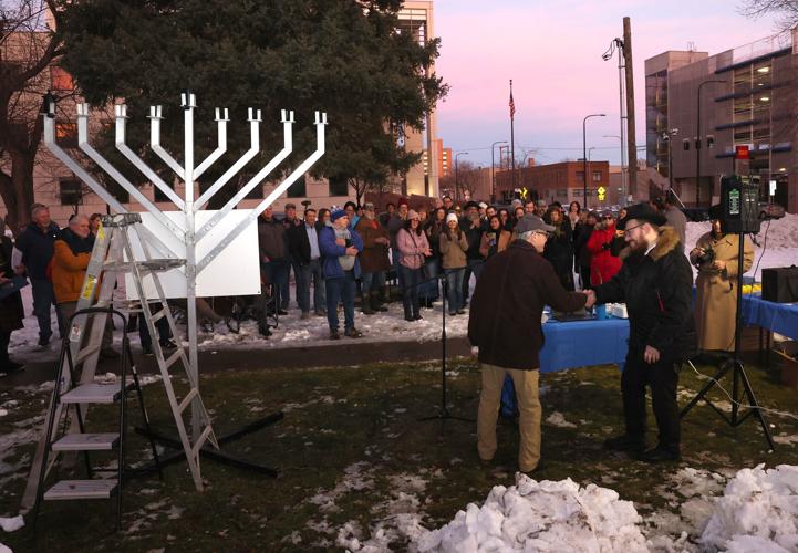 Rabbi Shaul Shkedi lights a Hanukkah menorah in Billings
