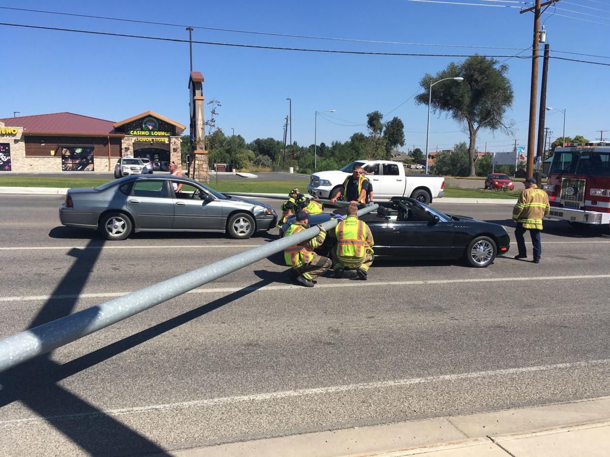 No injuries after light pole topples onto two cars at busy Heights ...