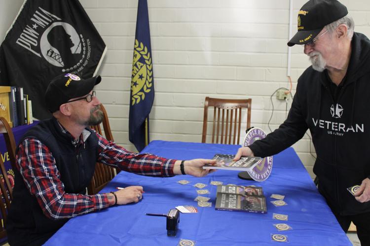 Three-time Purple Heart awardee Matthew Sims signs copies of his latest ...