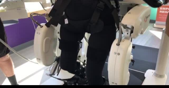 Natalie demonstates the Lokomat device that helps clients learn to walk ...