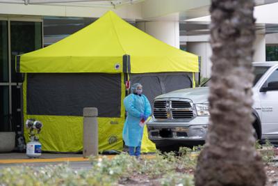 Kaiser employee is positioned outside hospital as part of coronavirus ...