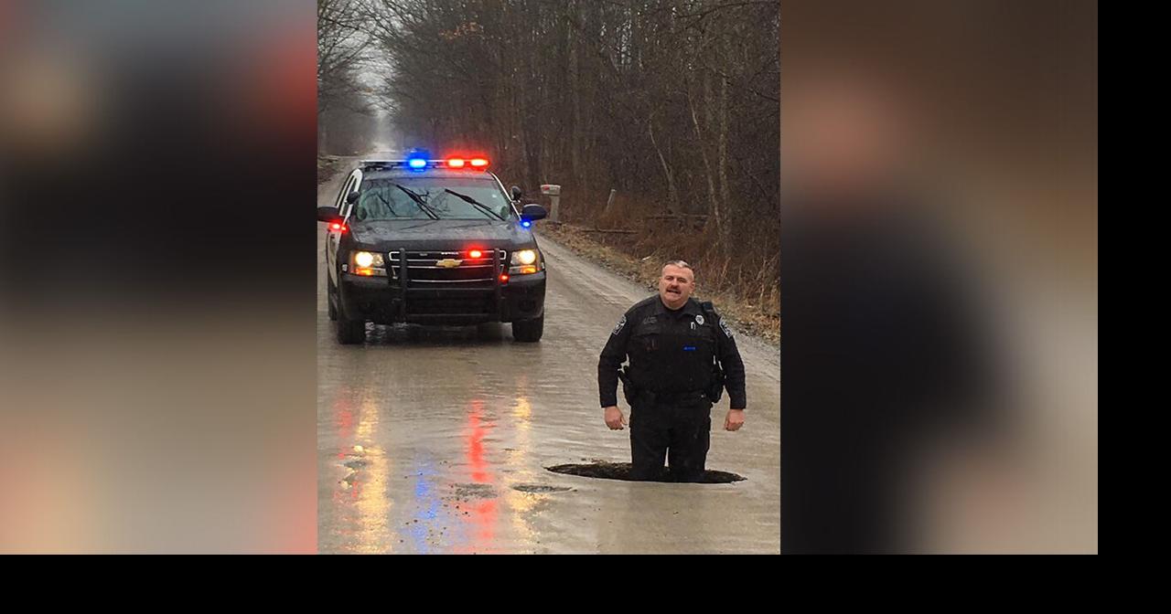 Deep pothole appears to be swallowing Michigan police officer ...