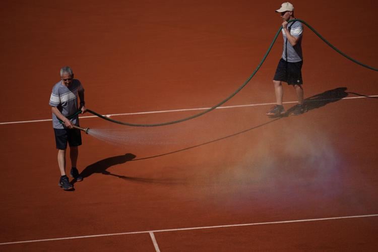 French Open groundskeepers drench the clay courts with water and salt ...