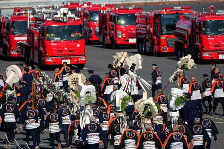 Photos show ladder stunts and other activities at a Tokyo fire brigade ...