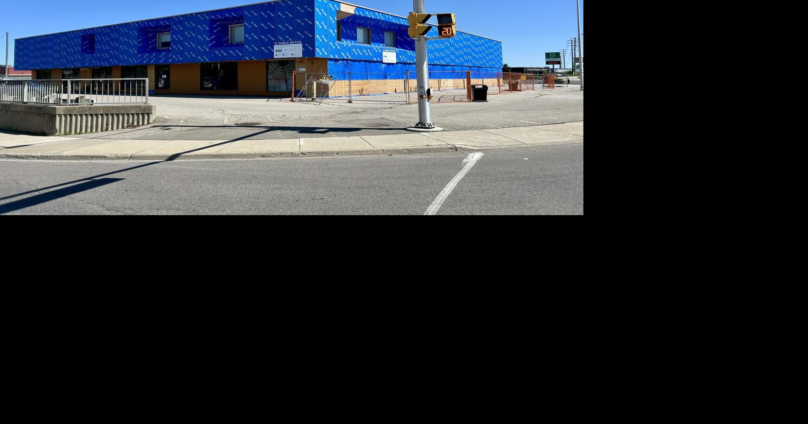 Building covered in blue wrap at major Milton intersection