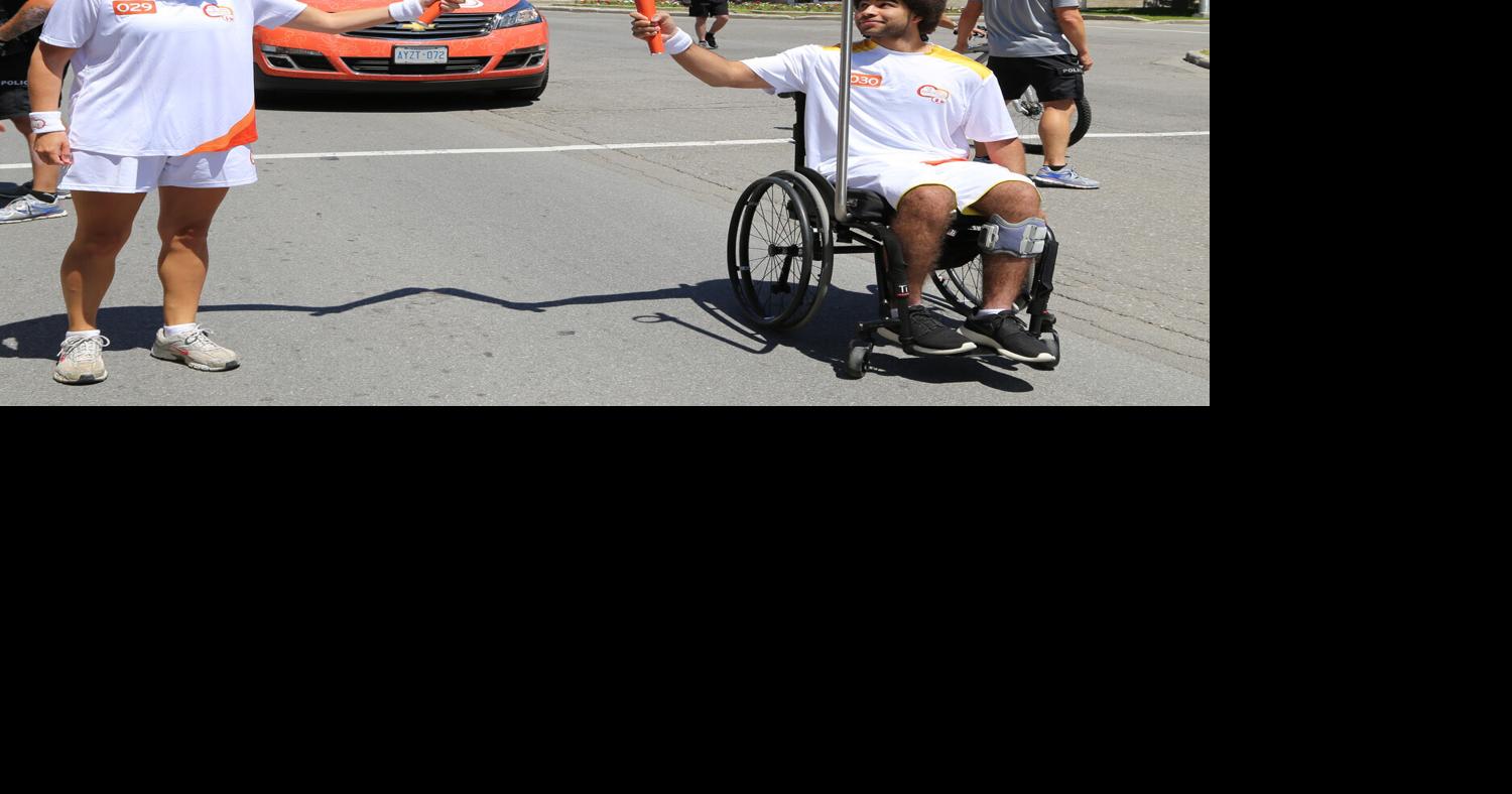 Neil Doef lights community cauldron during Torch Relay through Smiths Falls
