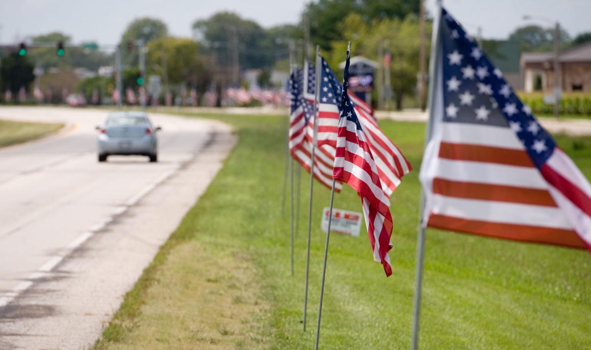 Flags lining funeral procession route for Navy service member