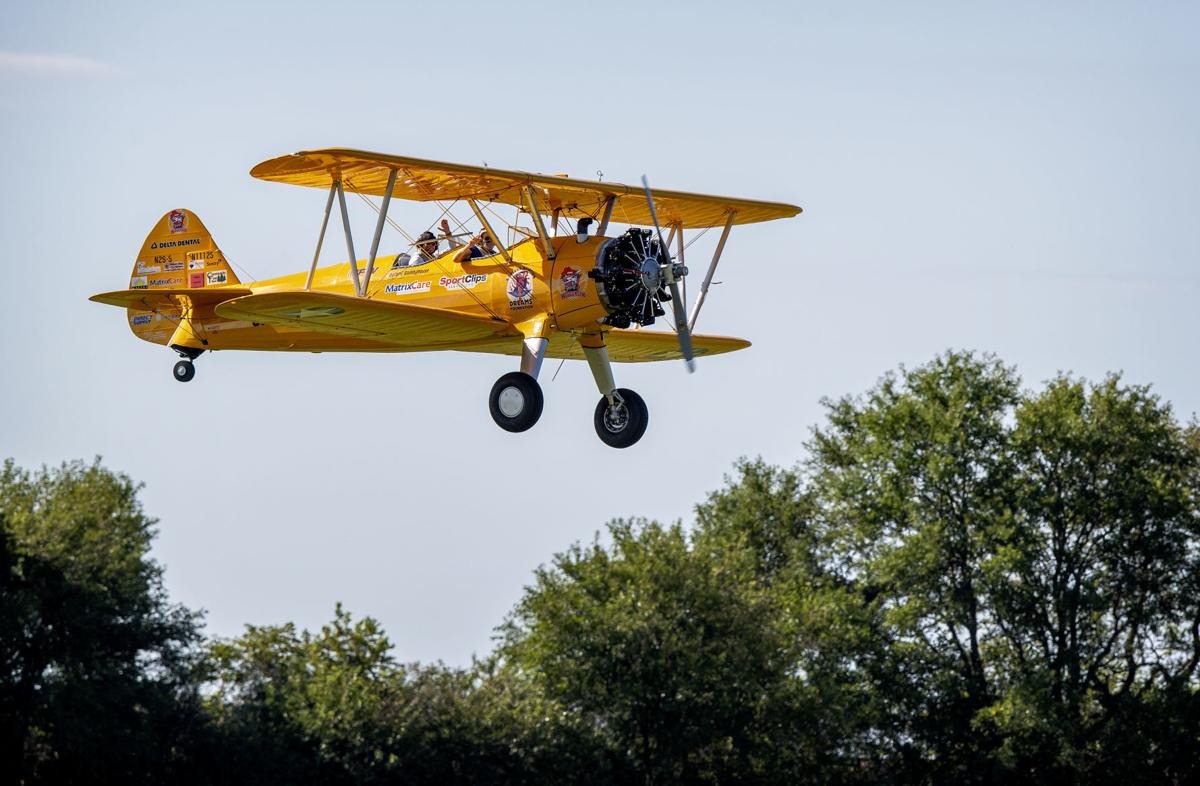 A crop duster in a World War II trainer plane gives the rides of his ...