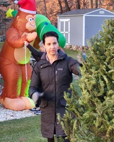 Neighbor Liz Kravig decorates an evergreen outside Chris and Katie ...