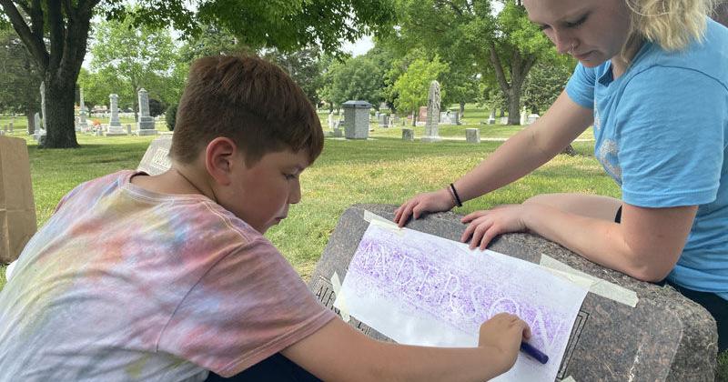 Students learn Kearney history 'rubbing' cemetery headstones