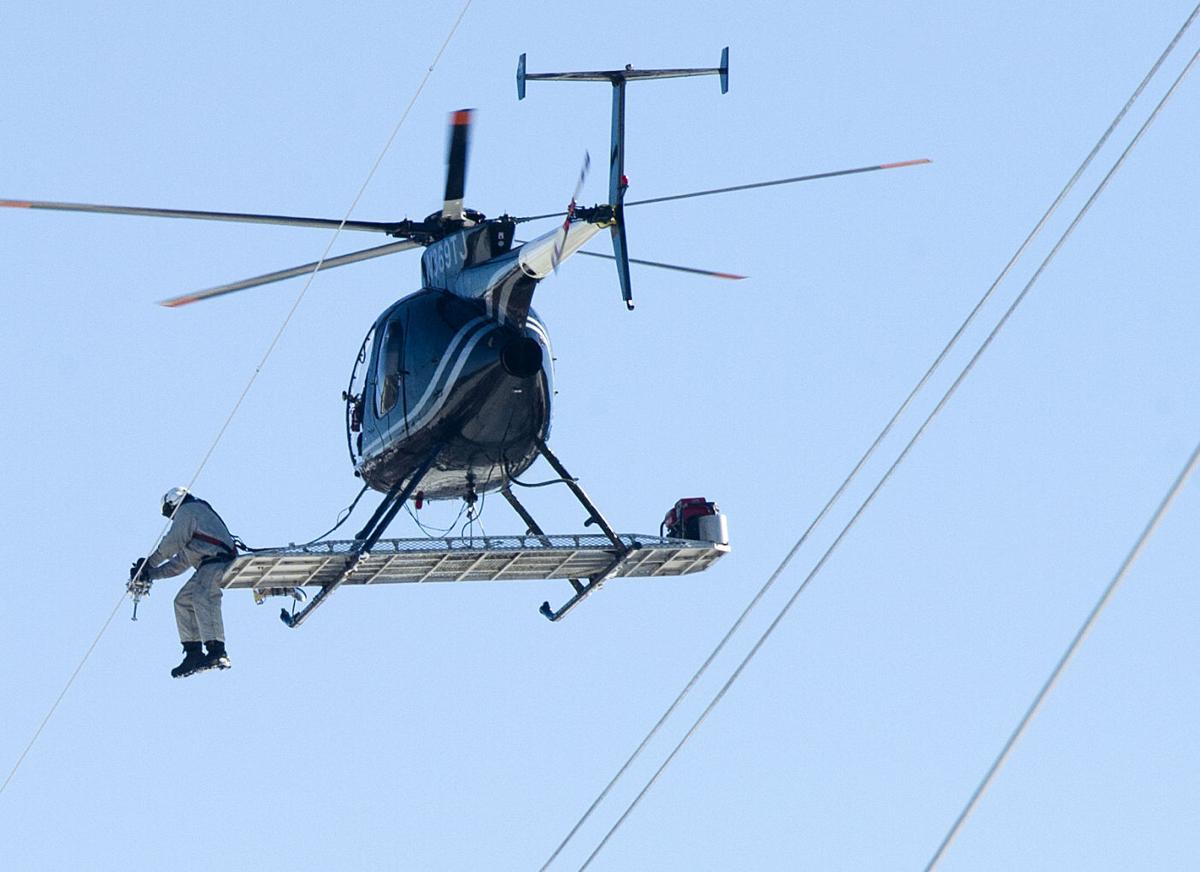 High wire act: Linemen use helicopter to string transmission project ...