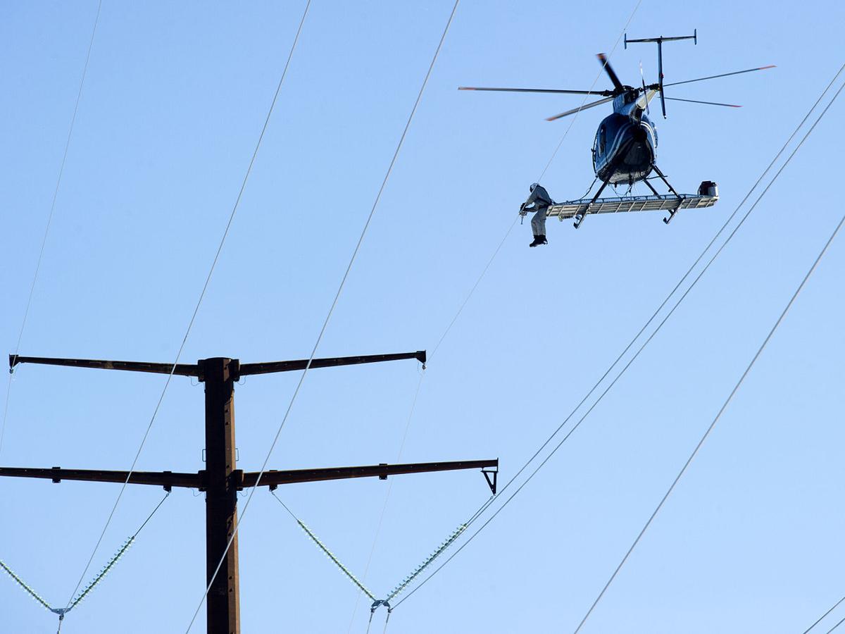 High wire act: Linemen use helicopter to string transmission project ...
