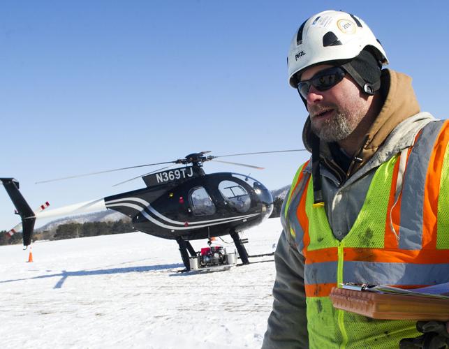 High wire act: Linemen use helicopter to string transmission project