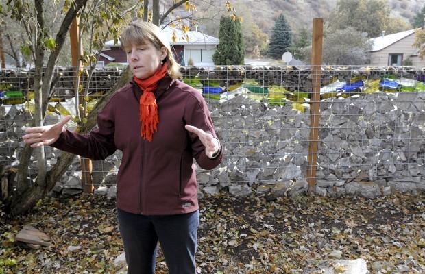 Prism of light: Woman uses empty wine bottles to fill part of fence