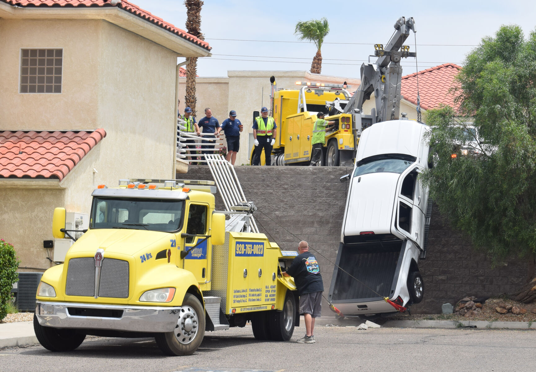 Two suffer minor injuries after truck falls down parking lot embankment ...