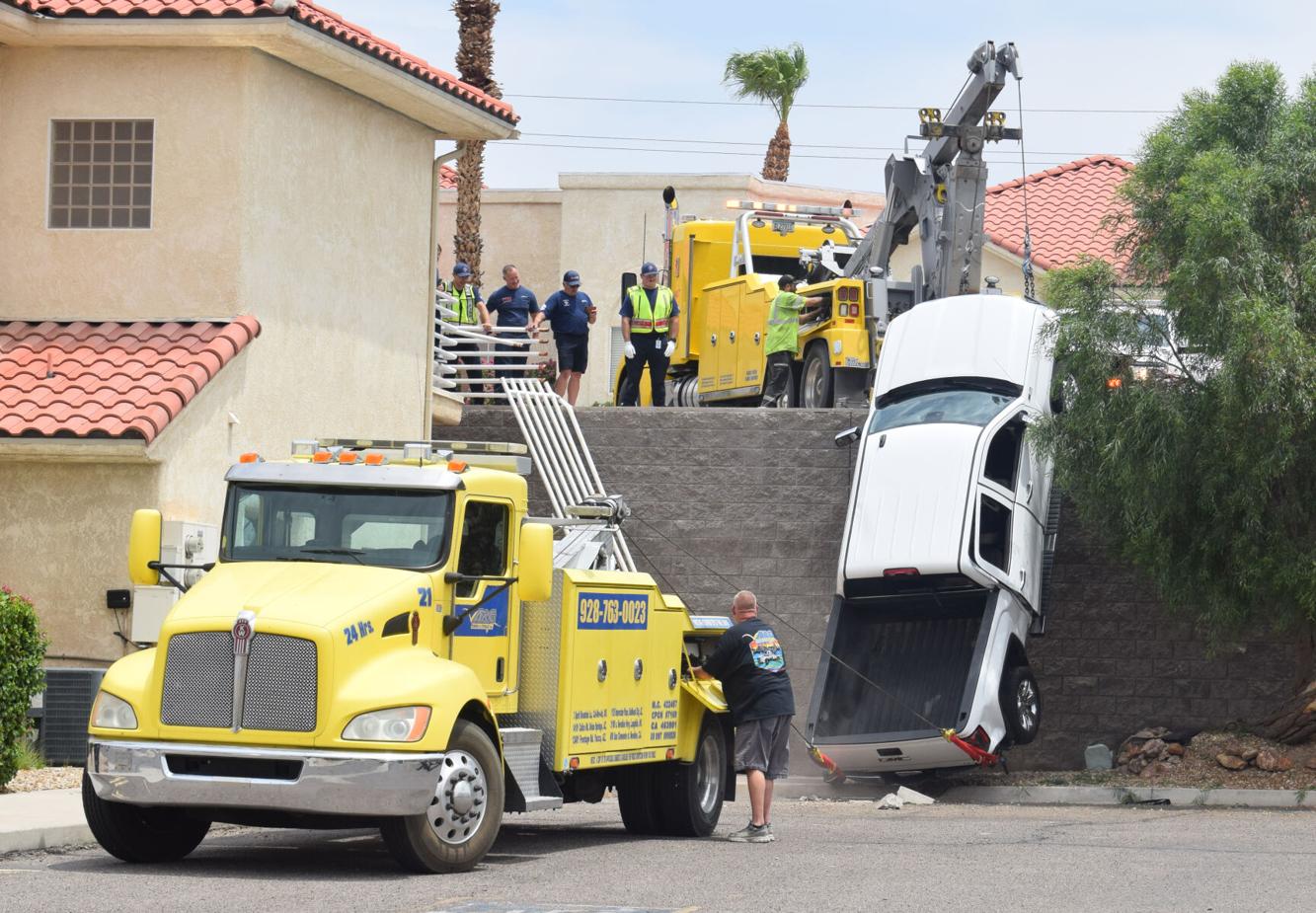 Two suffer minor injuries after truck falls down parking lot embankment ...