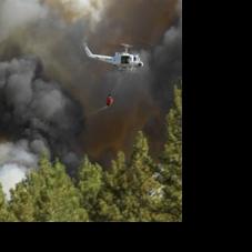 Noble Fire A helicopter pours water from a bucket on the Noble Fire ...