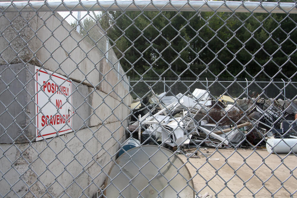 Fence erected around scrap metal pile at landfill