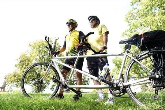 Volunteers help visually impaired ride a bike