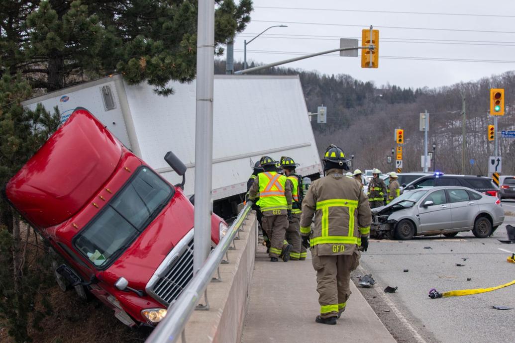 Transport truck hangs from QEW overpass after Grimsby crash