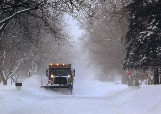 Police, plows working snow-covered, slick roads