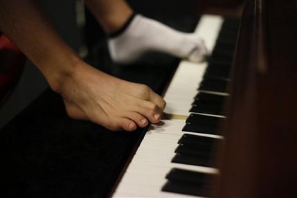 Man with no arms plays piano with toes