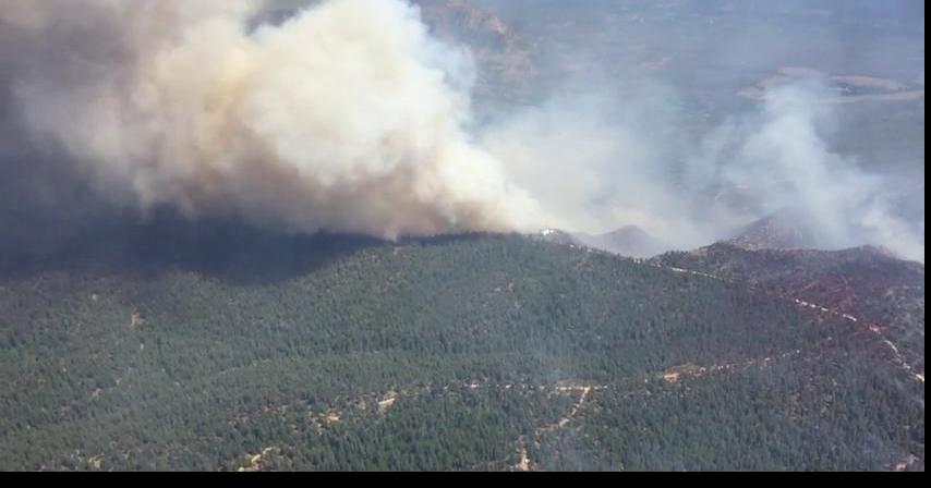 Aerial view of firefighters laying fire retardant in the path of the ...