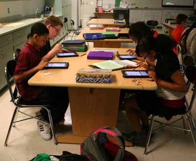 Students handing in their homework on iPads