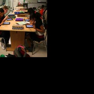 Students handing in their homework on iPads
