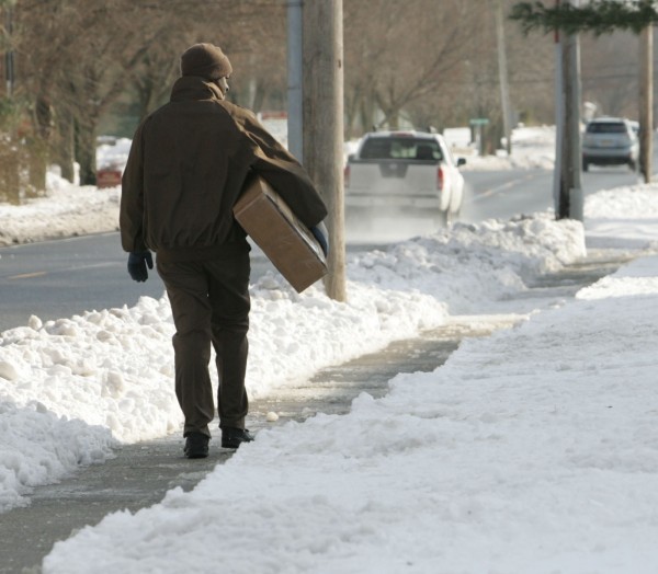 Workers push through snow to deliver holiday mail