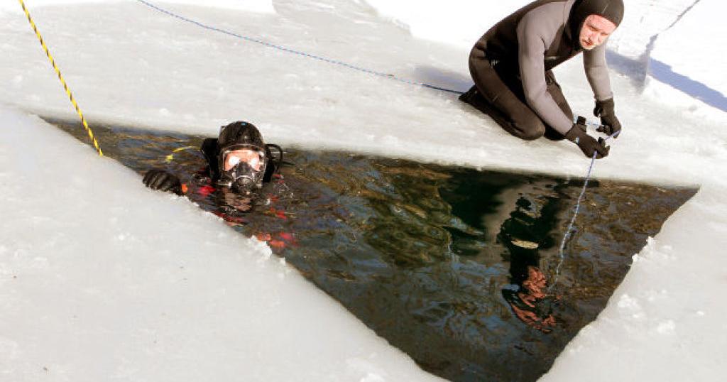 Scuba divers go under the ice