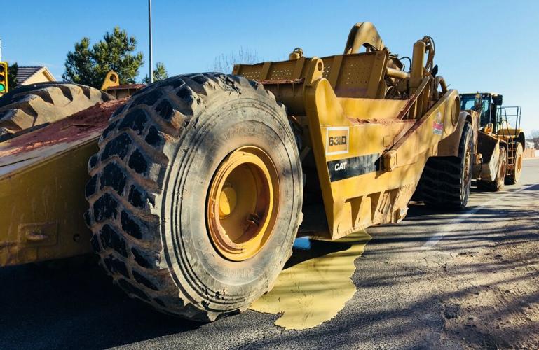Huge construction scraper loses wheel, spills hydraulic fluid onto ...
