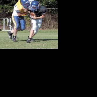 Freshman quarterback Evan Brock takes a hit behind the line of ...