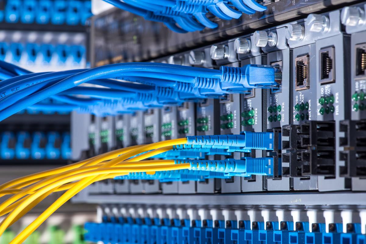 AdobeStock_100999003 Fiber Optic cables connected to optic ports and ...