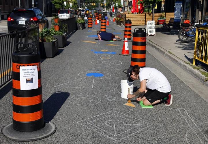 Photos: Road murals being painted on Hunter Street in downtown Peterborough
