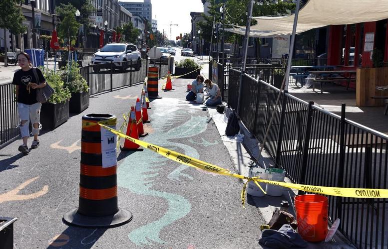 Photos: Road murals being painted on Hunter Street in downtown Peterborough