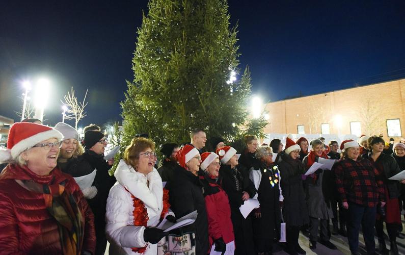 People celebrate a tree lighting ceremony at Quaker Square