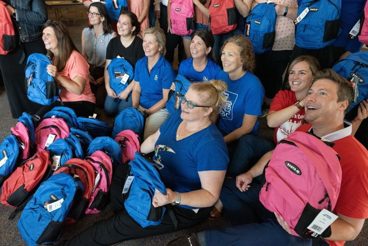 Volunteers stuff backpacks with school supplies