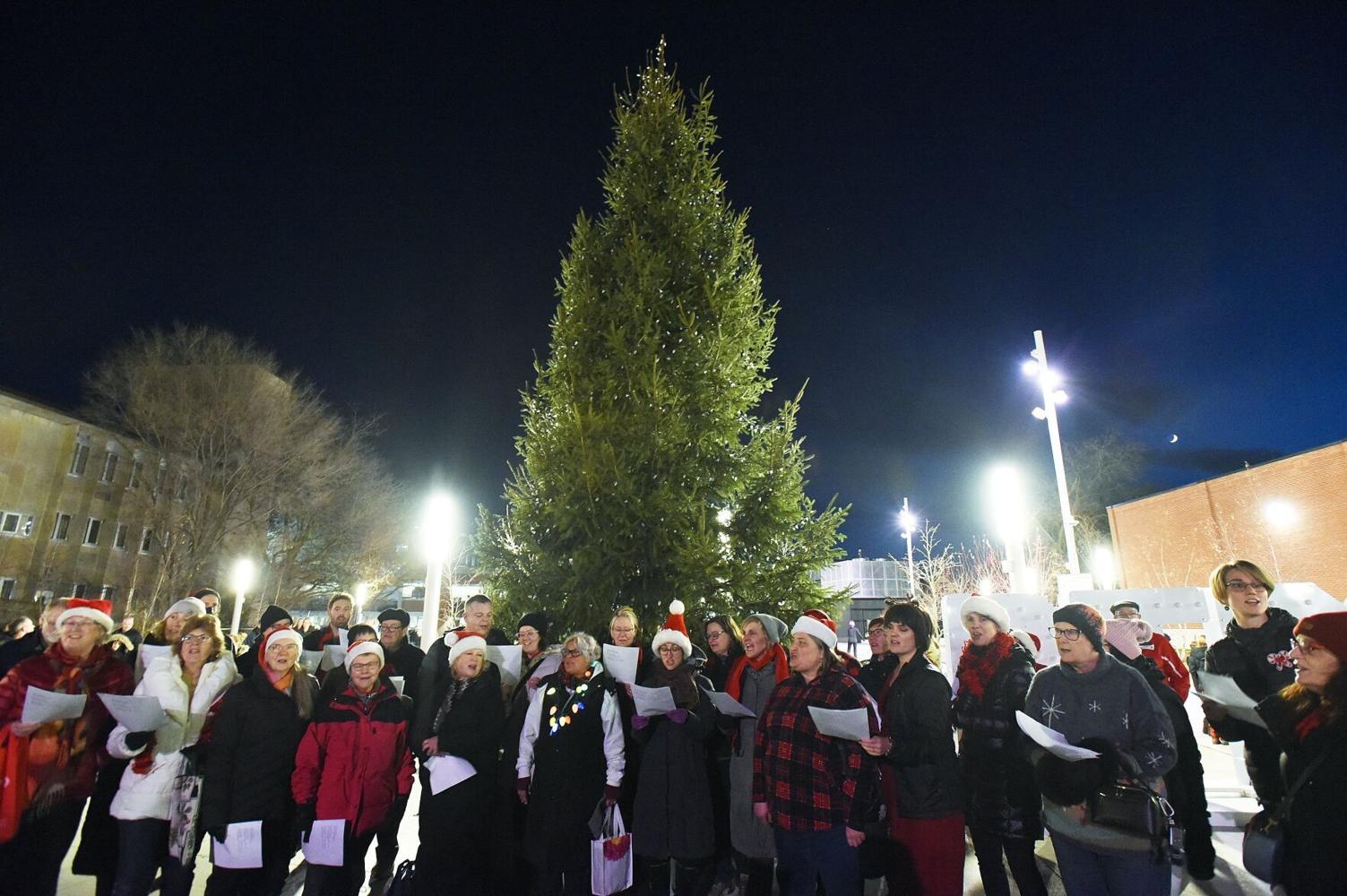 People celebrate a tree lighting ceremony at Quaker Square