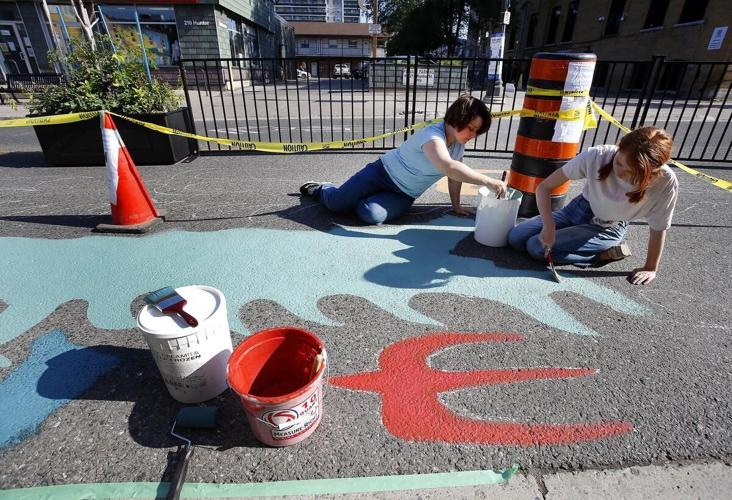 Photos: Road murals being painted on Hunter Street in downtown Peterborough