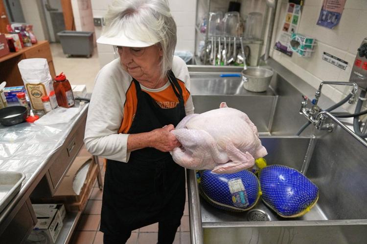 A cafeteria worker prepares a Thanksgiving meal to feed hundreds