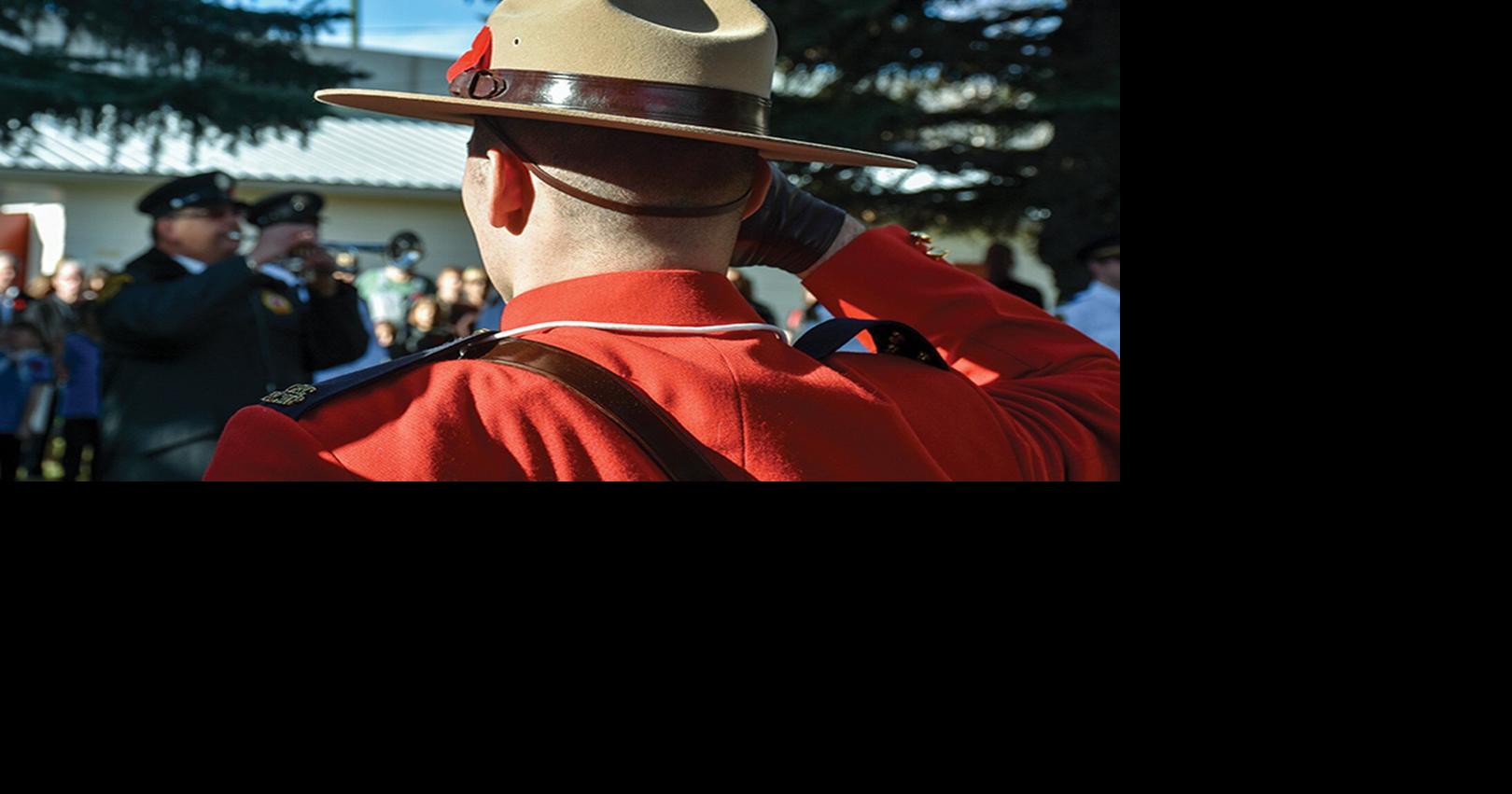 RCMP officers stand with veterans for Remembrance Day