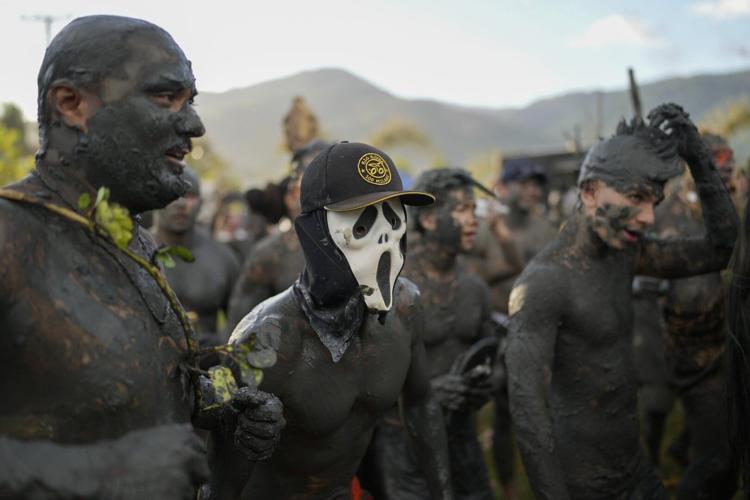 Mud-covered Carnival revelers are a strange sight in sleepy Brazilian town