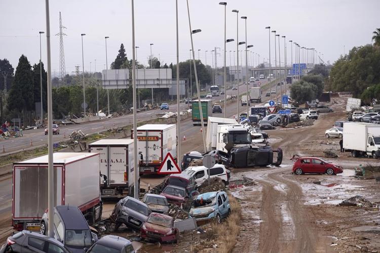 Mud-caked volunteers clean flood debris in a Spanish town as ...